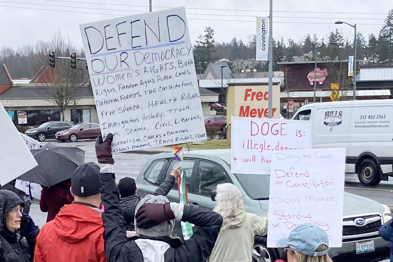 People line Covington street to protest Trump, Musk actions | Kent Reporter